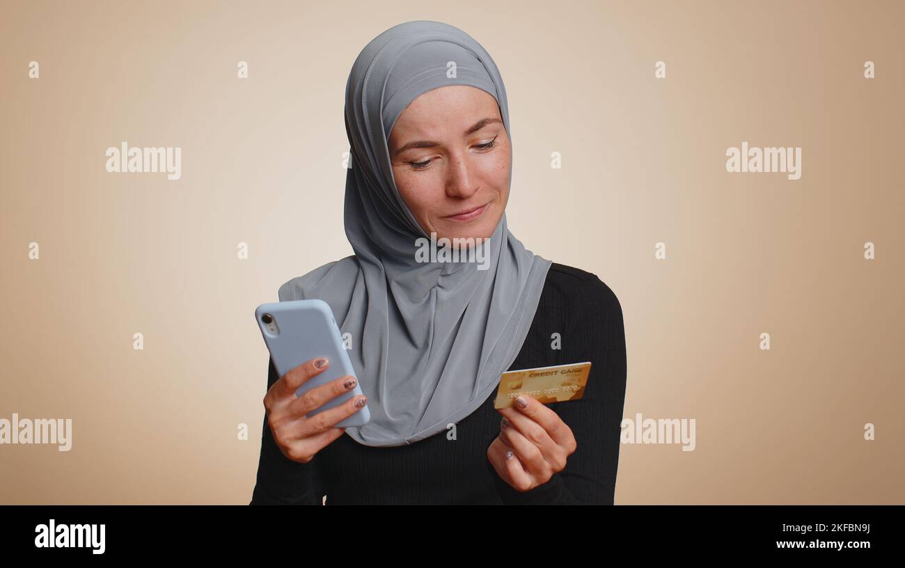 Sincere muslim woman in hijab customer using credit bank card and ...