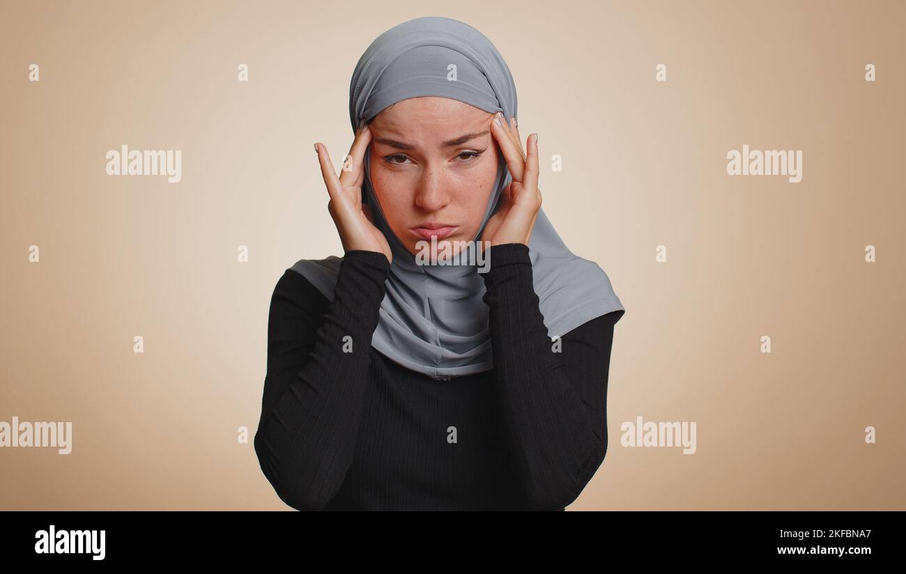 Unhealthy young muslim woman in hijab rubbing temples to cure headache ...