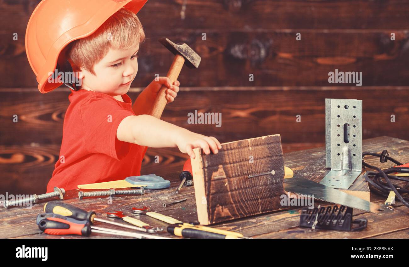 Toddler on busy face plays with hammer tool at home in workshop. Kid ...