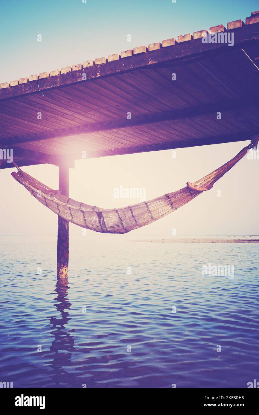 Empty hammock hanging under a sea wooden pier, getaway concept, color ...