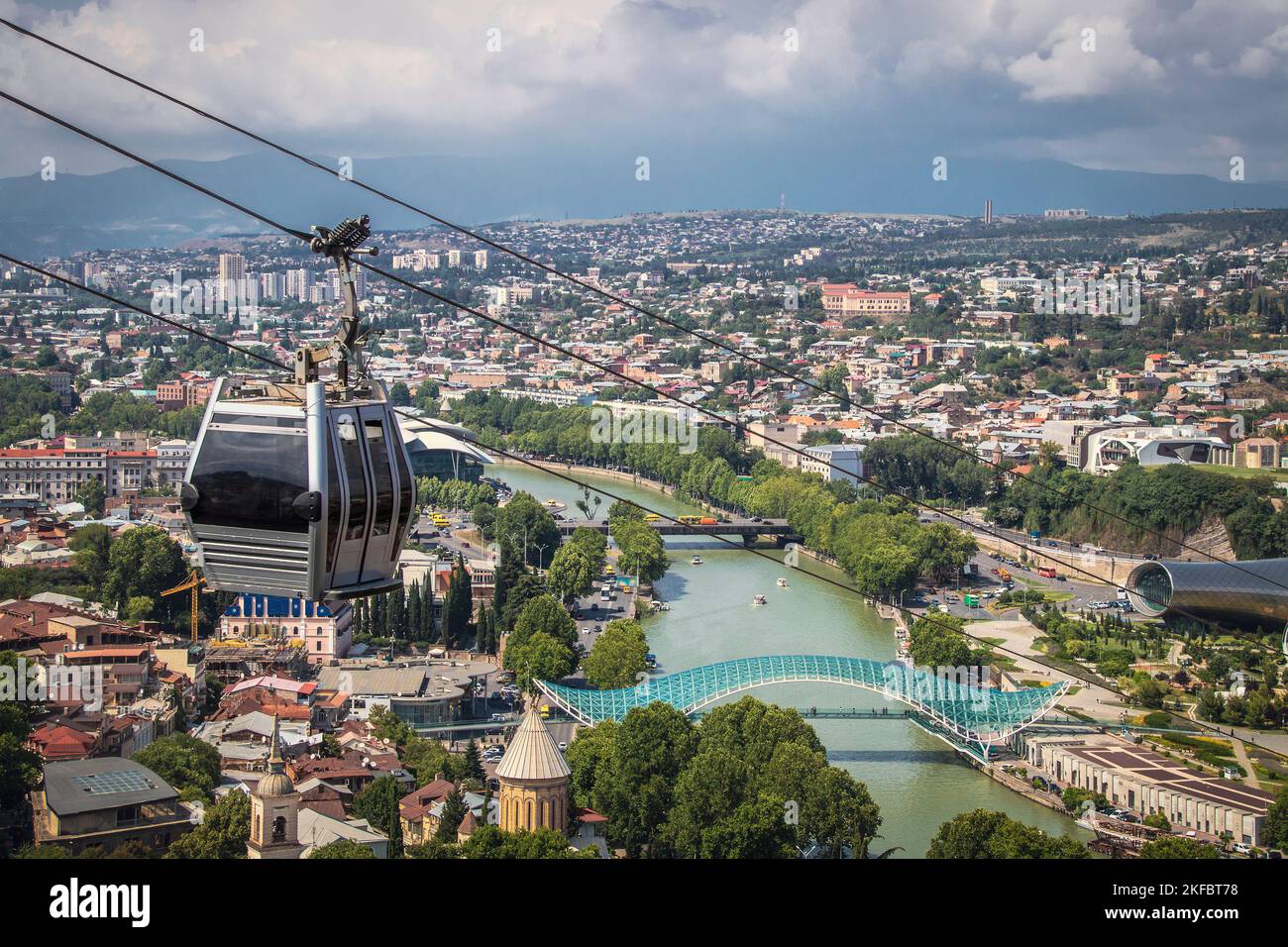 Tbilisi aerial tramway on cable above city and the Mtkvari -Kura River and Peace pedestrian ...