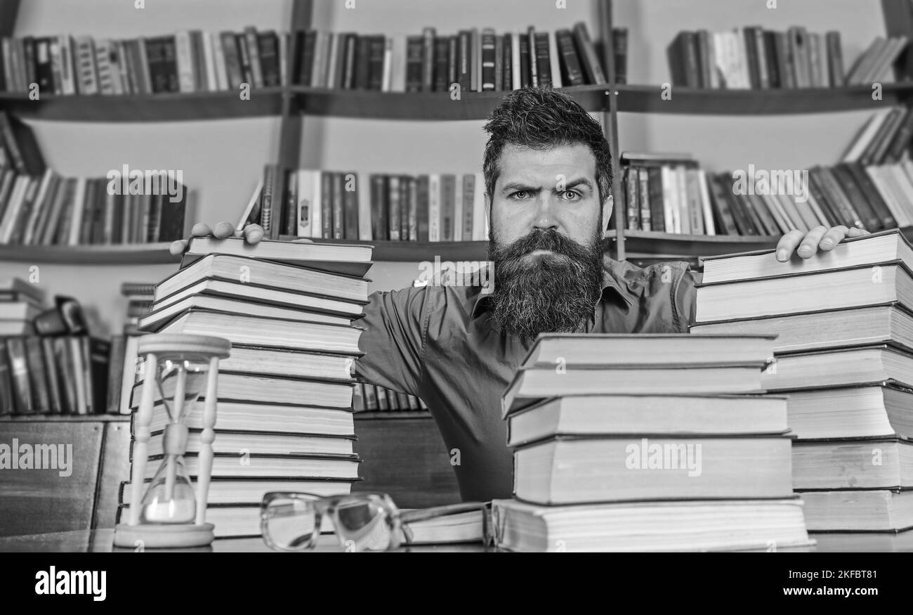 Teacher or student with beard sit at table with hourglass and glasses ...