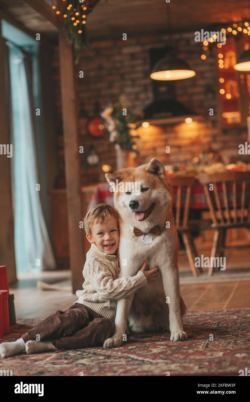 Smiling small child having fun with dog waiting for miracle Santa at ...
