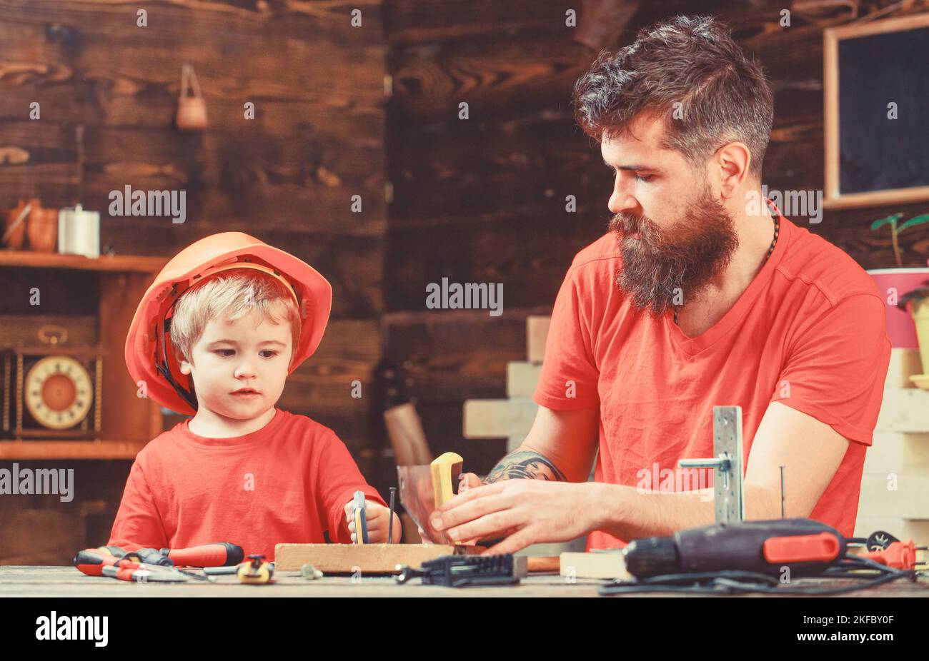 Fatherhood concept. Father, parent with beard teaching little son to ...