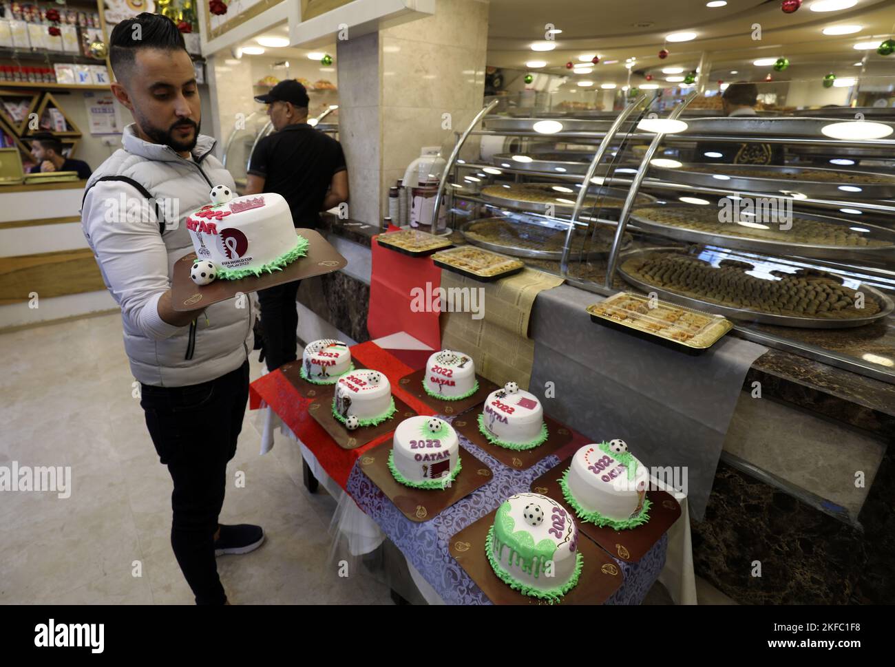 A Palestinian baker shows a cake decorated with items linked to Qatar's ...