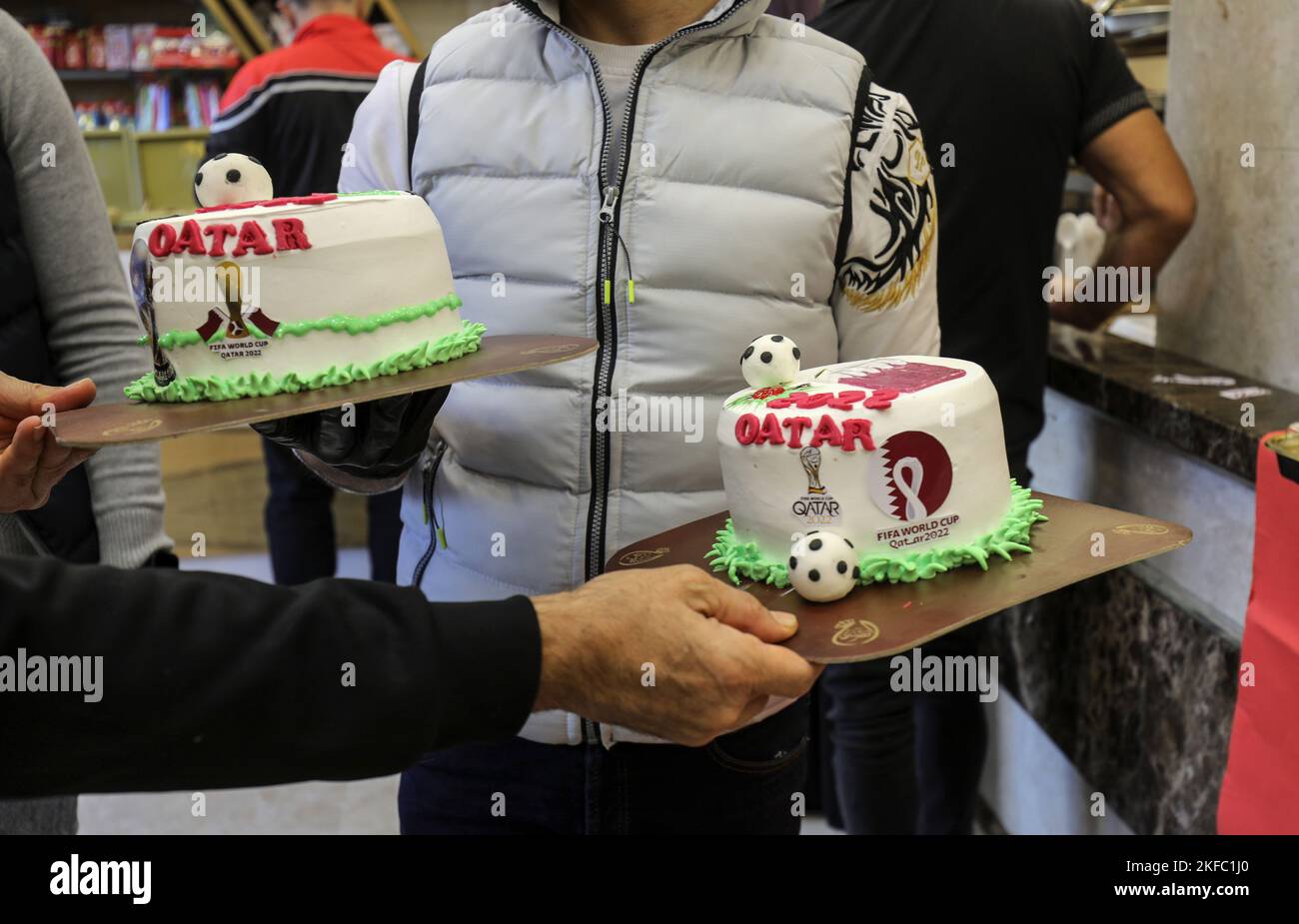A Palestinian baker shows a cake decorated with items linked to Qatar's ...