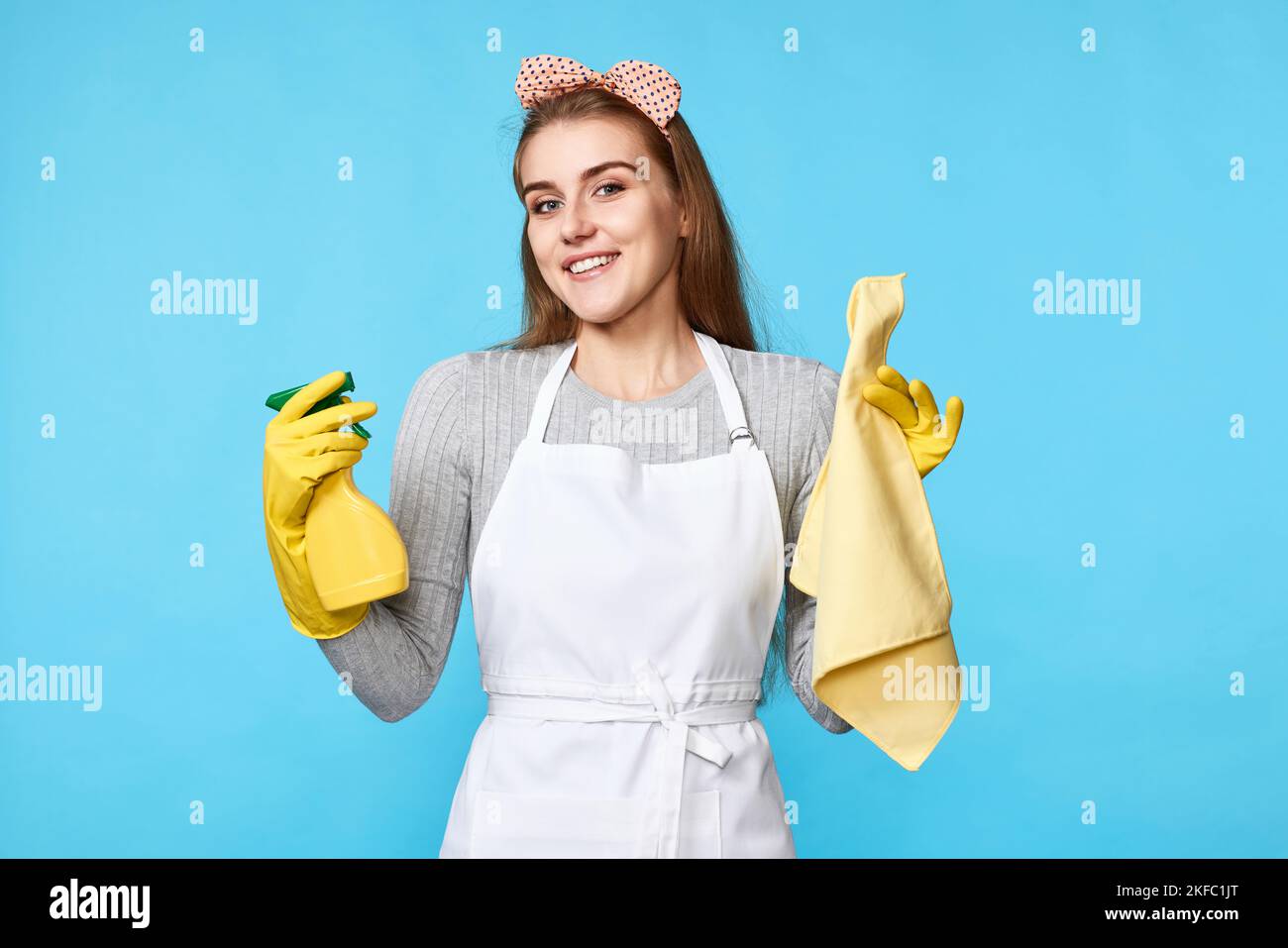 woman in gloves and cleaner apron with cleaning rag and detergent ...