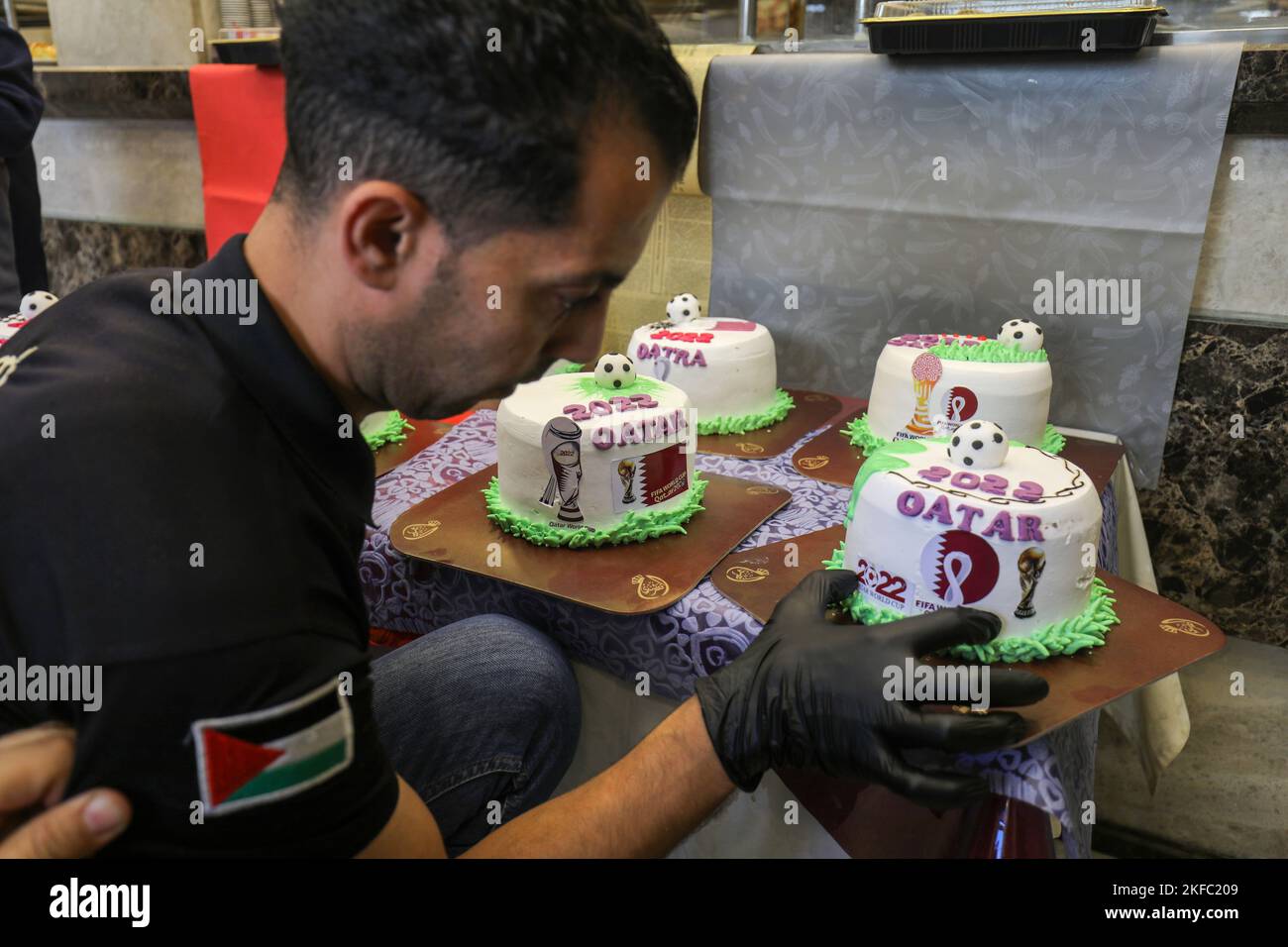 A Palestinian baker shows a cake decorated with items linked to Qatar's ...