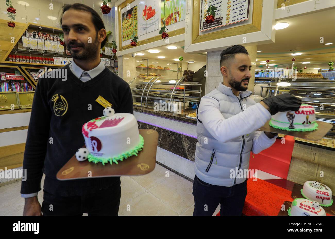 A Palestinian baker shows a cake decorated with items linked to Qatar's ...