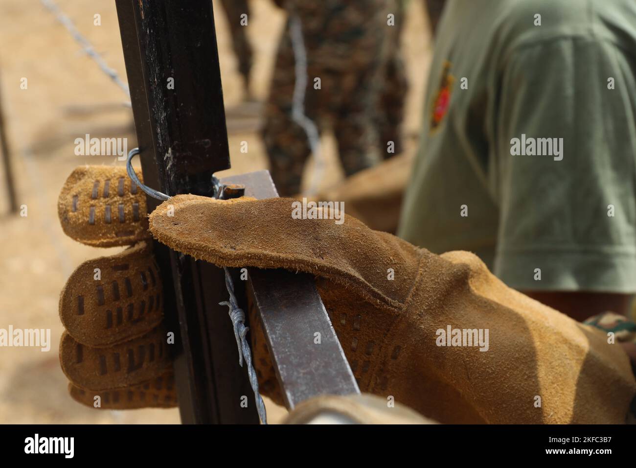 A Timor-Leste Defense Force (F-FDTL) soldier installs barbed wire onto ...