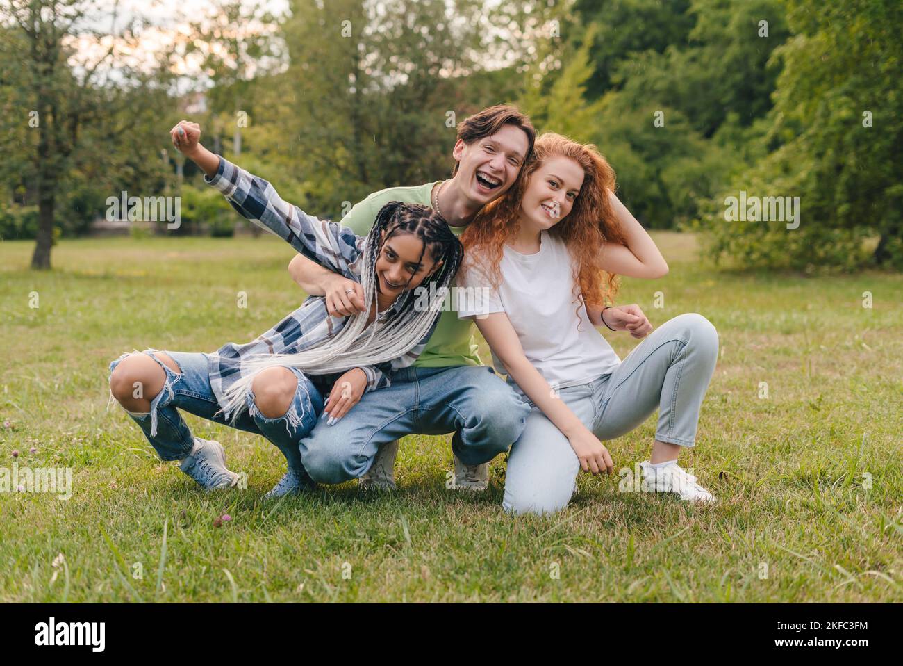 Cheerful boy and two girls creating trendy content on mobile app to ...