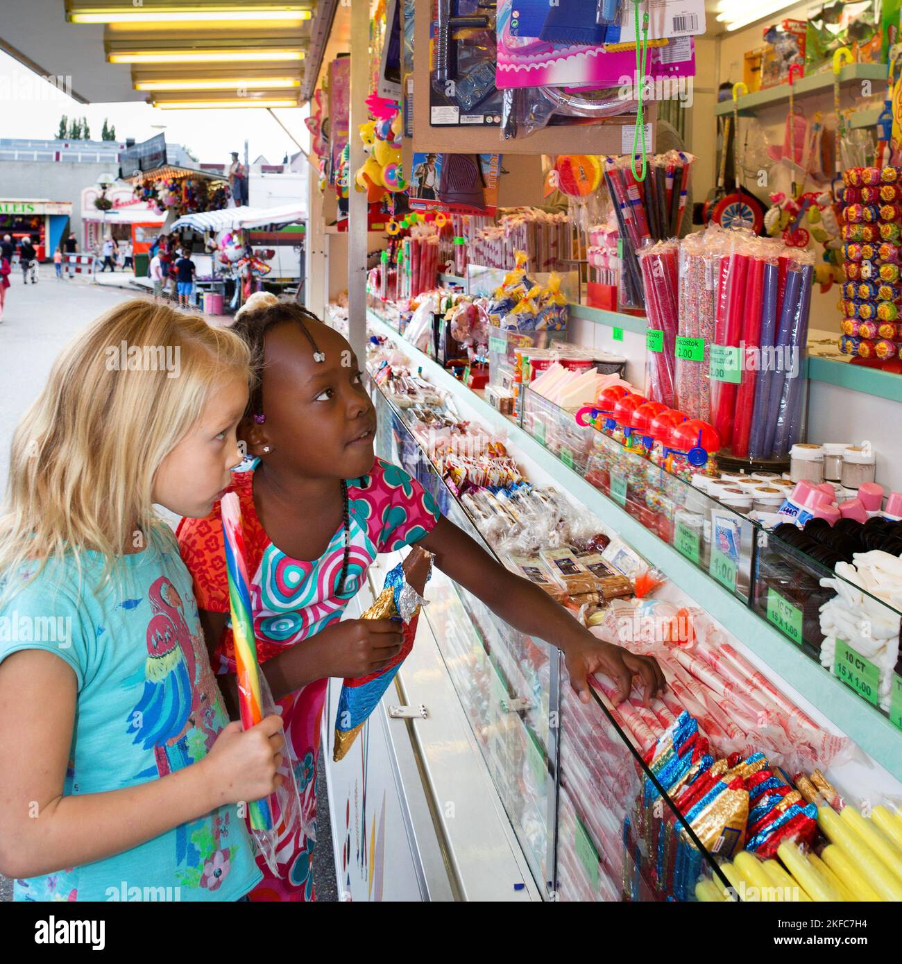 two little girls at a candy stal with a candy cane at a fair . Duiven ...
