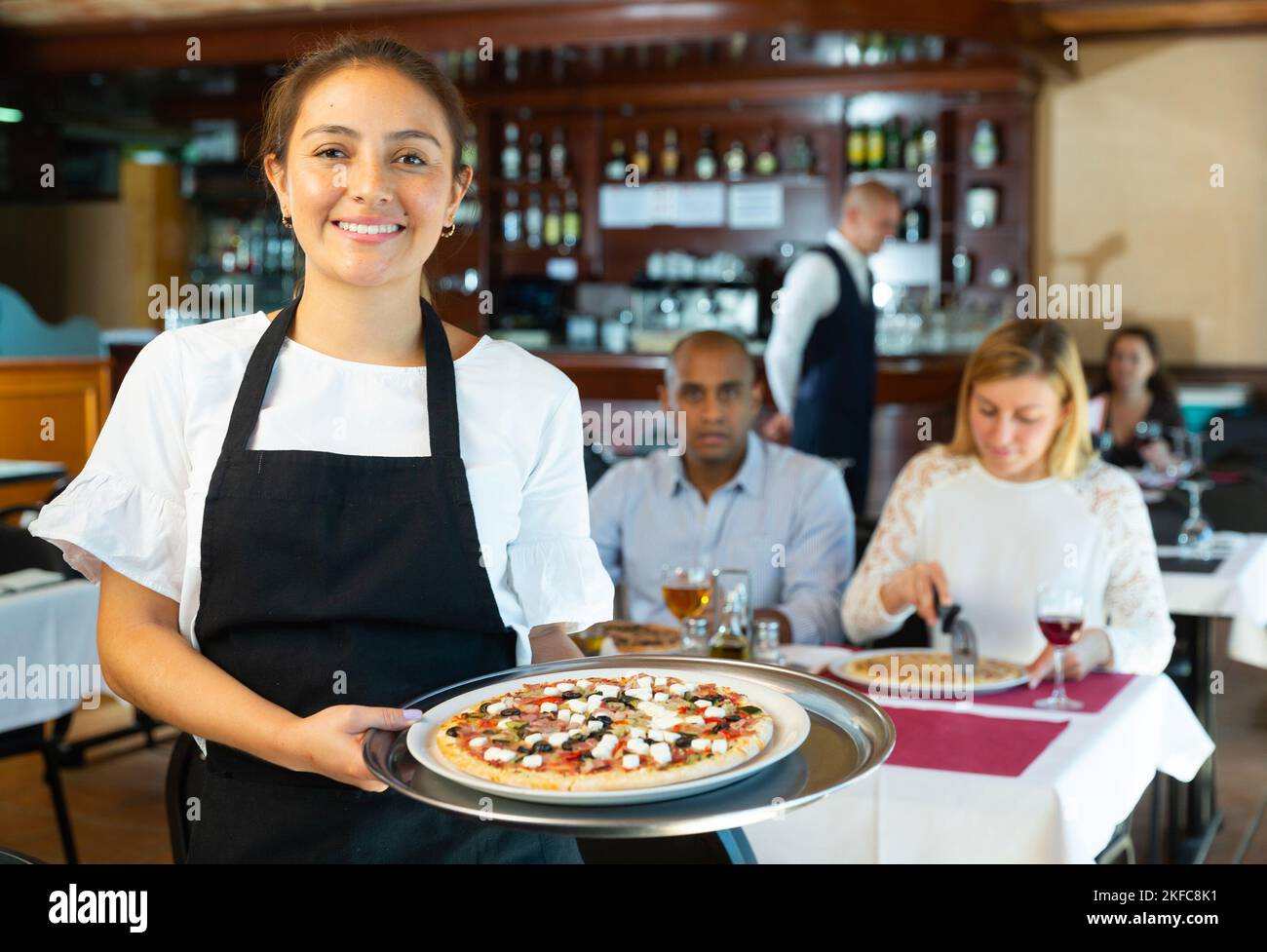 Smiling waitress serving pizza hi-res stock photography and images - Alamy