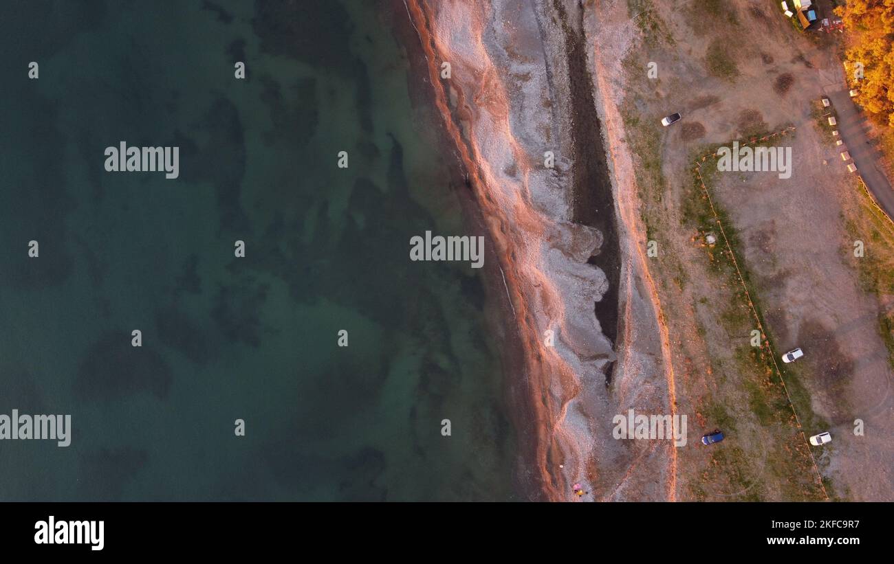 An aerial top shot of a scenic beach with dunes and a clear waterscape ...
