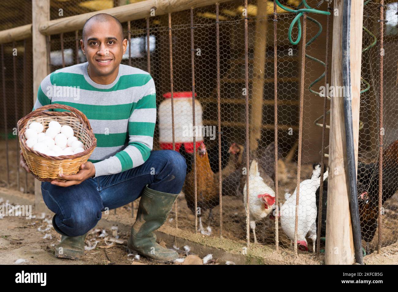 Smiling man holds a basket of chicken eggs in his hands Stock Photo - Alamy
