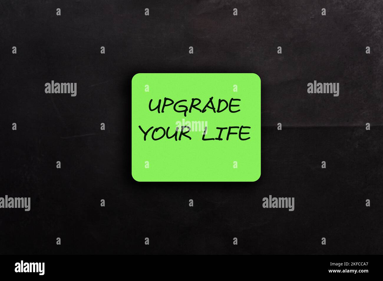 upgrade your life text on green sticker over black background. The ...
