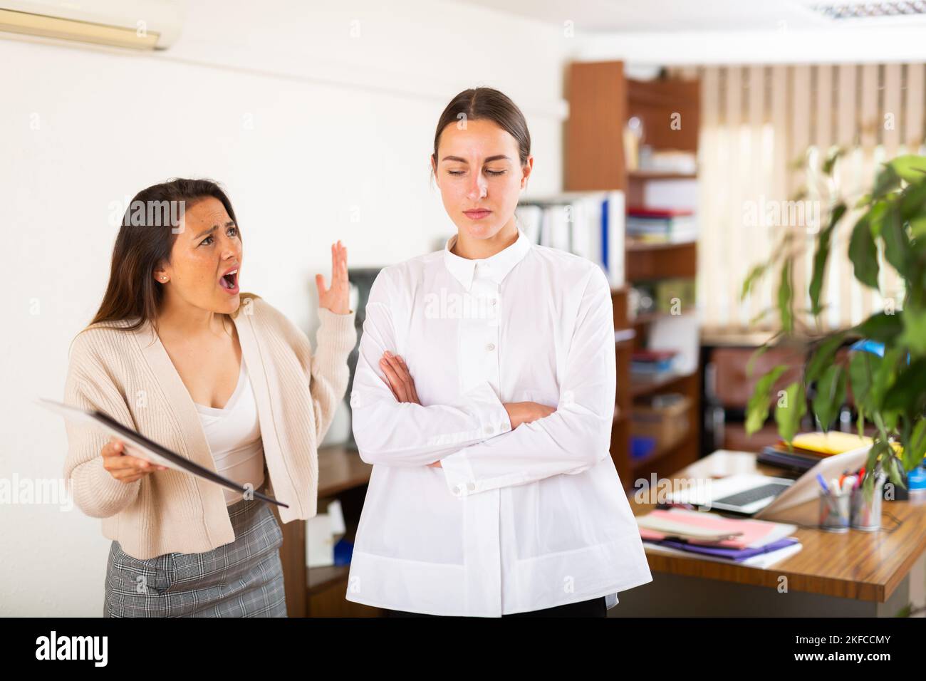 Unhappy woman chief screaming to young female manager Stock Photo - Alamy