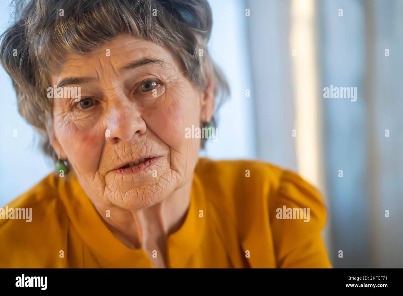 Old retired gray-haired woman in yellow blouse Stock Photo - Alamy