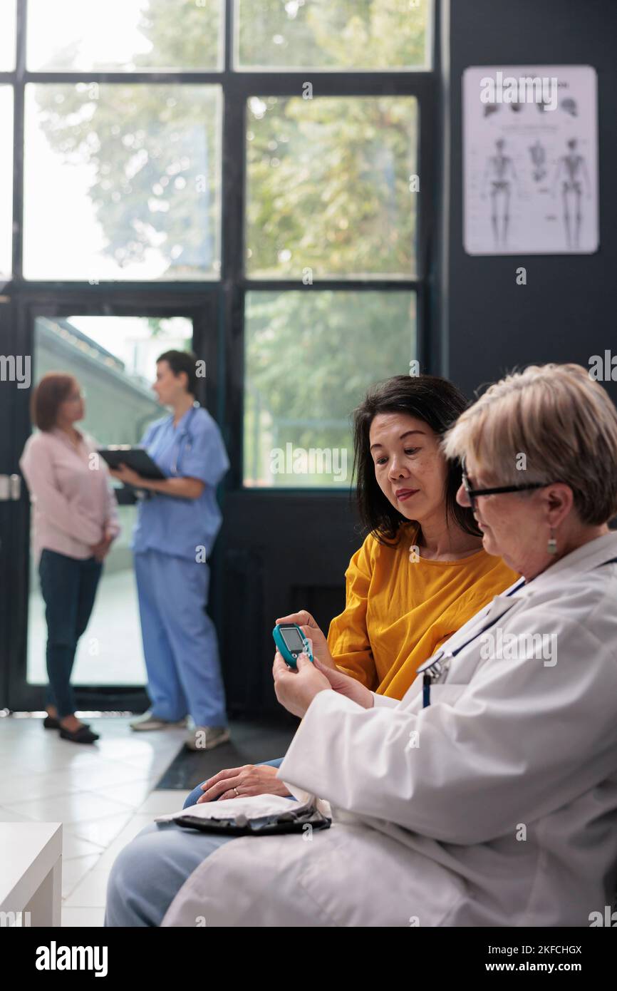 Senior medic measuring insulin level and glucose in blood sample using ...