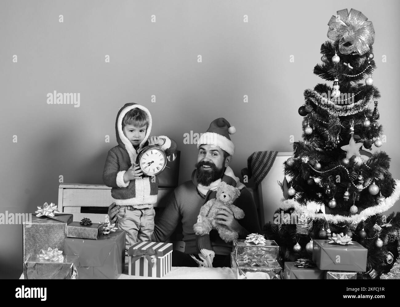 Santa and little elf hold clock showing five to midnight Stock Photo ...