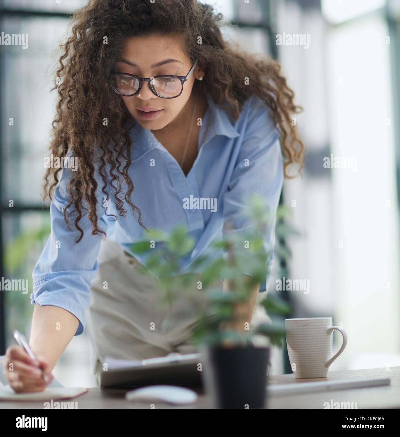 A young woman makes a report in the office. Woman writing notes for ...