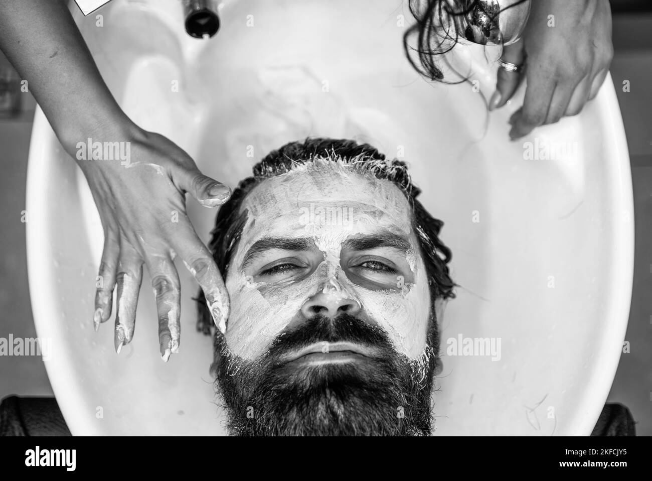 Hairdresser washes client man head in barbershop and use foam cream ...