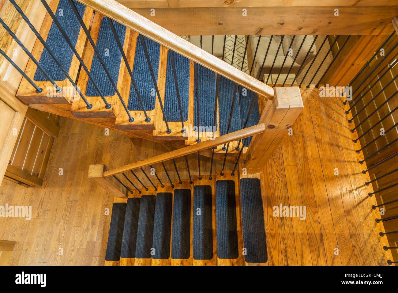 Top view of wooden staircase and banister with black wrought iron ...