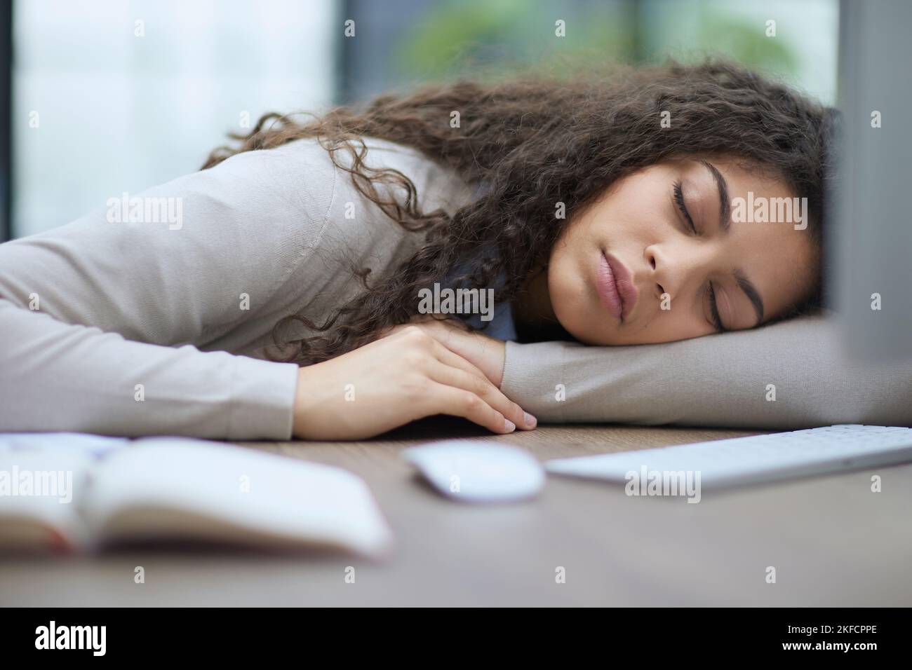 Portrait of a beautiful business woman sleeping on the table in the ...