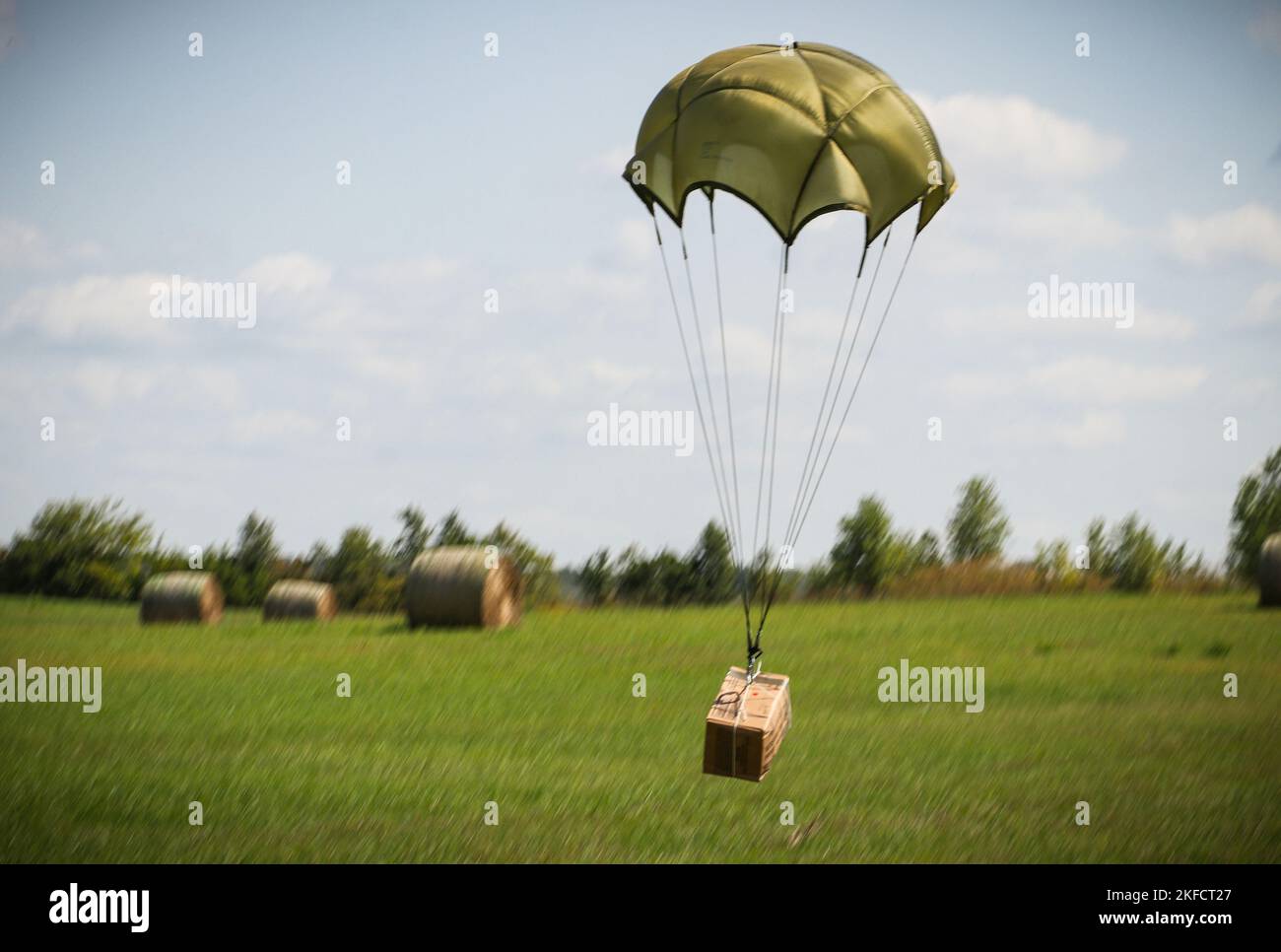 A box of Meals-Ready-to-Eat floats to the ground during an air drop and ...