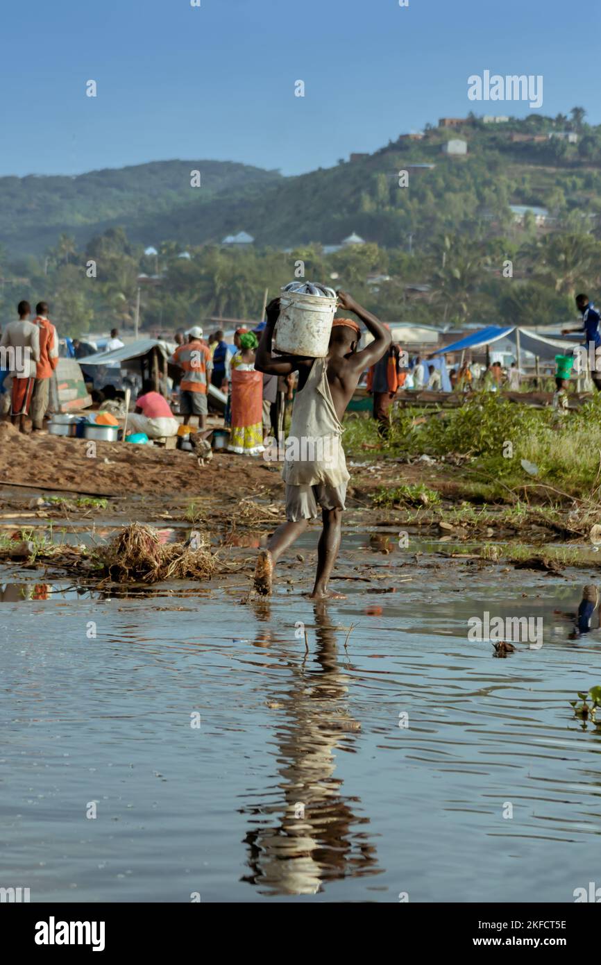 An African fisherman with a bucket of fish in the lake Rumonge Stock ...