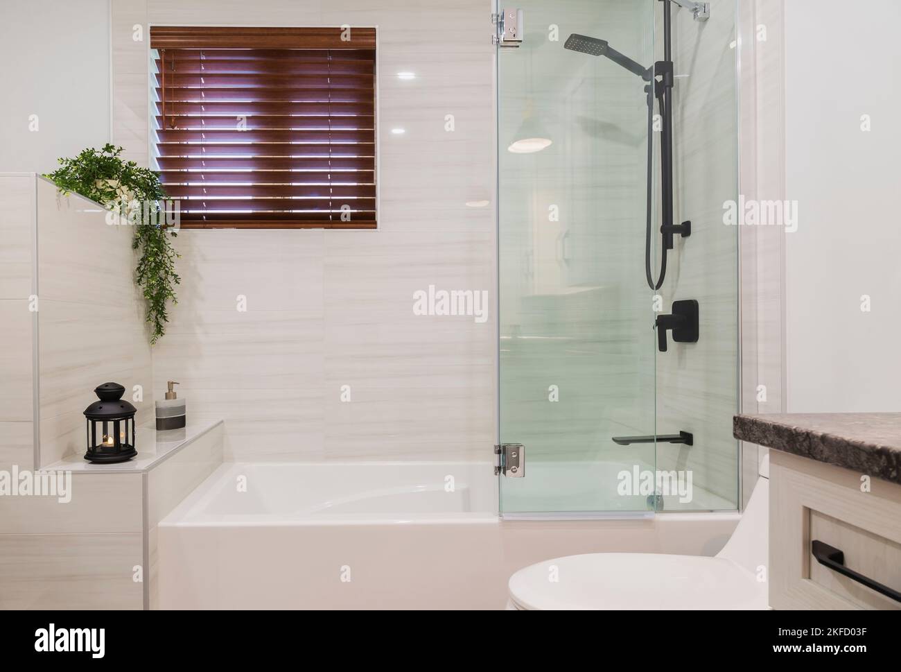 Bathtub with glass shower panels and toilet in bathroom inside ...