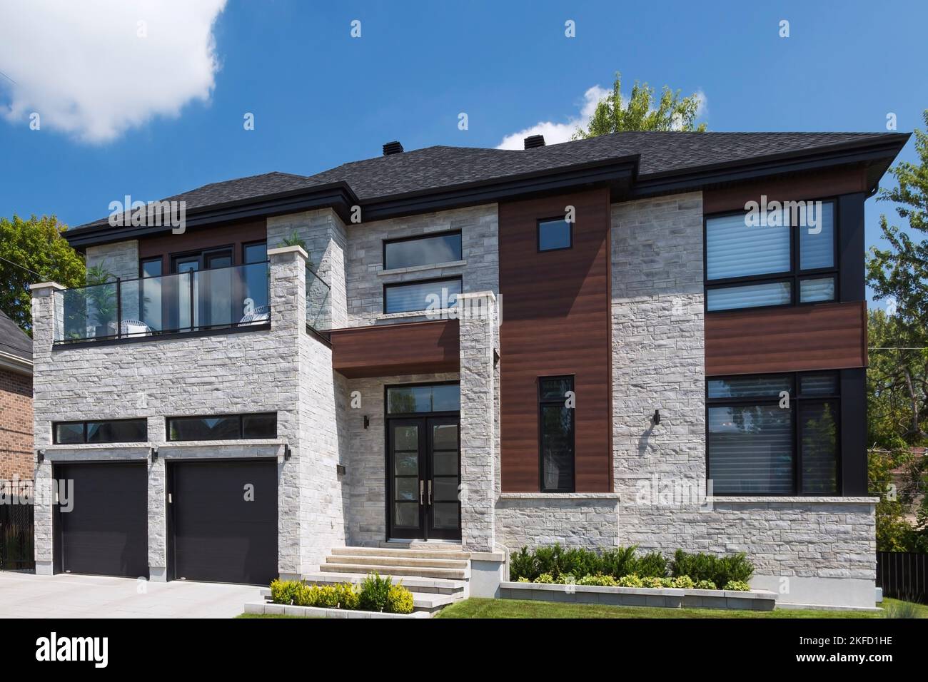 Grey cut stone and brown stained wood cladded with black trim ...