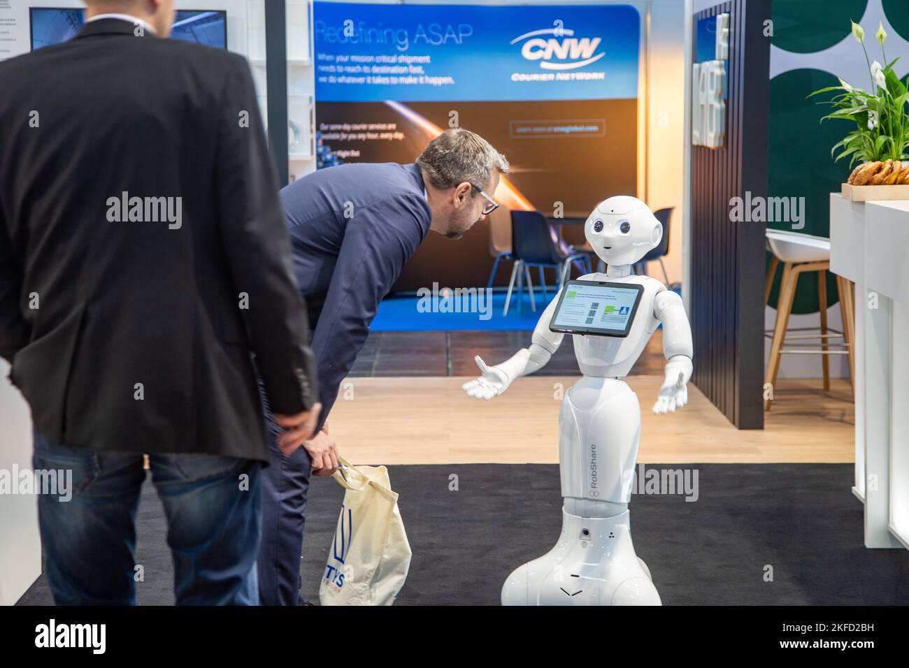 Mann spricht mit Roboter bei der Electronica / Semicon Europa Messe, der Weltleitmesse und ...