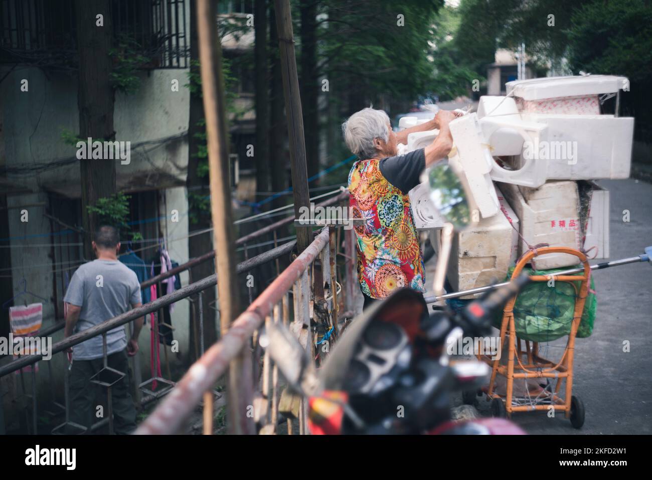 A man collecting old objects in a poor neighbourhood in China Stock ...