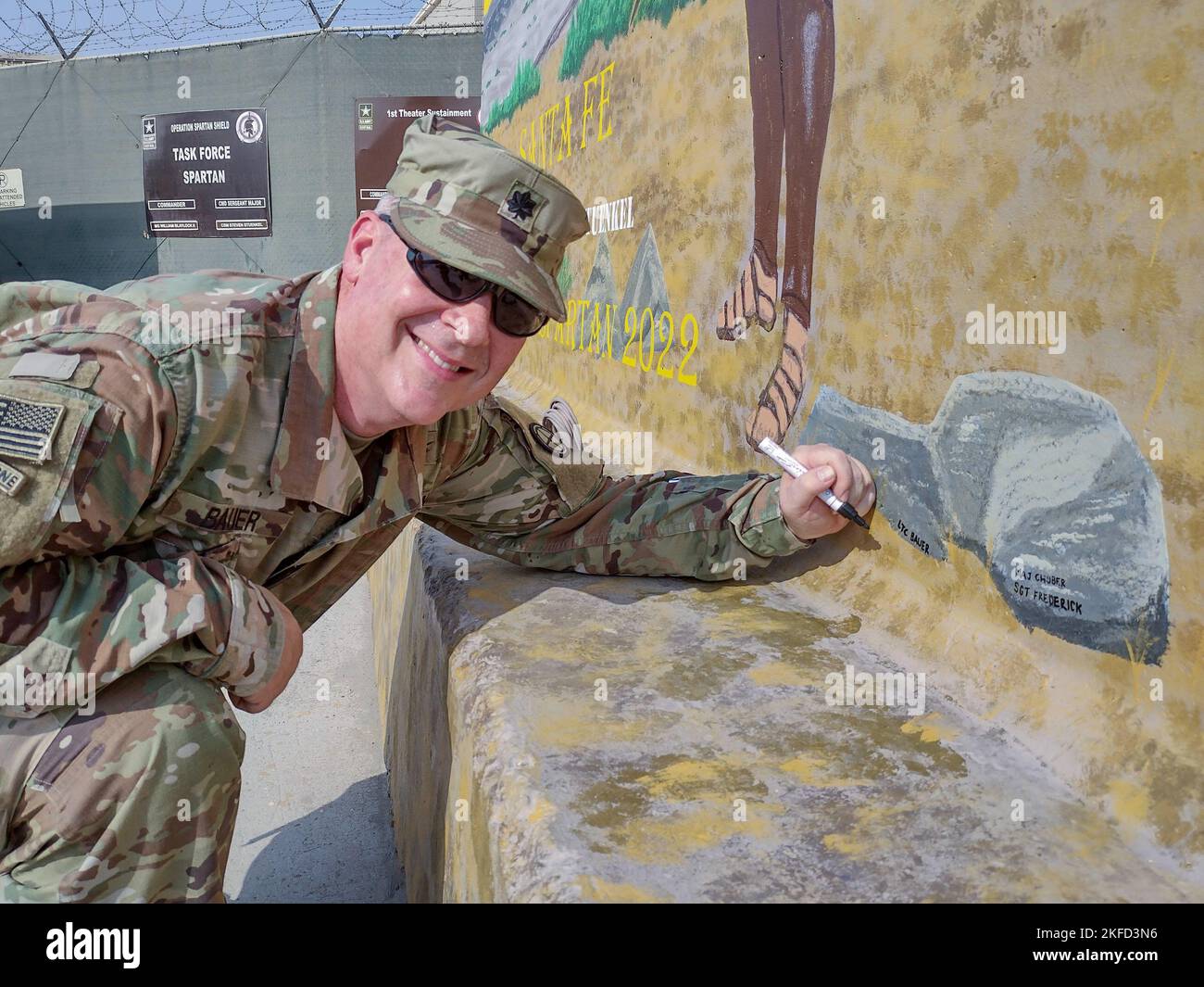 U.S. Army Soldier Lt. Col. Mark Bauer signs his name on a T-Wall on ...