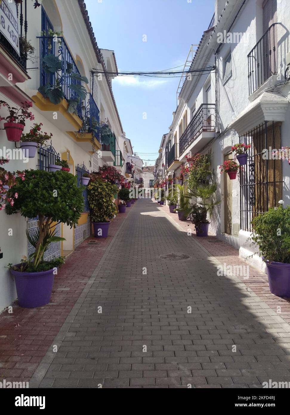 A narrow street surrounded by buildings in Estepona Stock Photo - Alamy