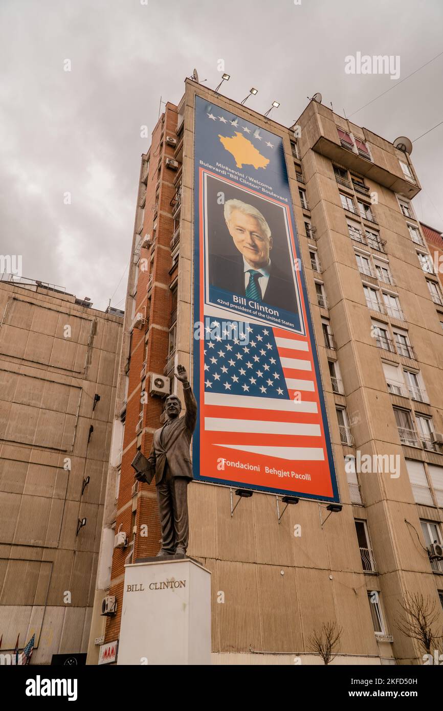 A vertical view of Bill Clinton banner and statue in downtown Pristina ...