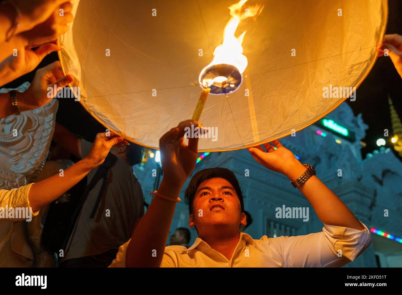 A man lighting a paper lantern during Pchum Ben celebrations near Phnom ...