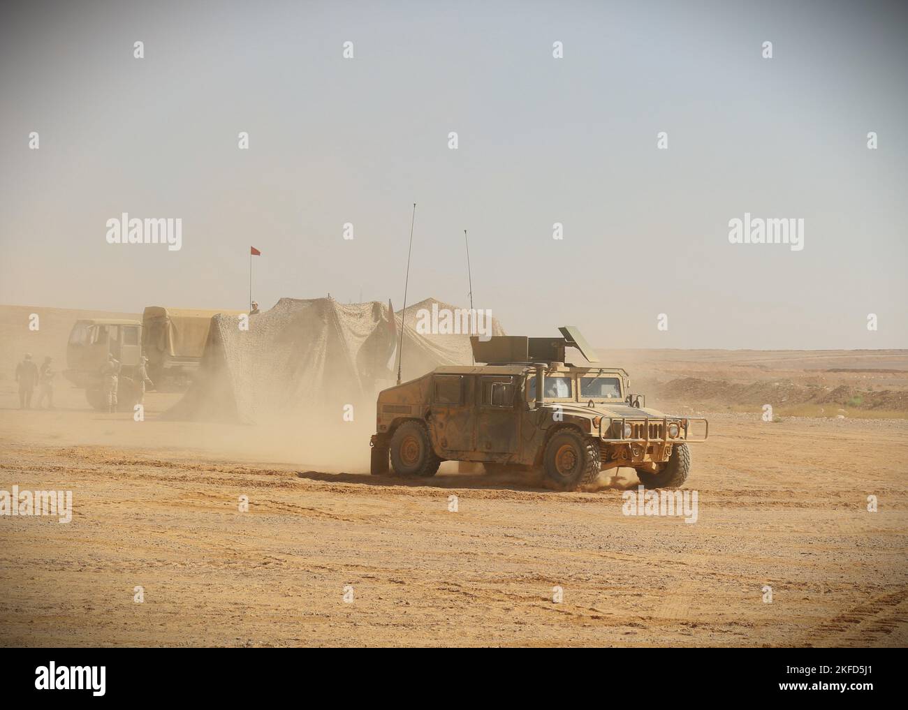 A High Mobility Multipurpose Wheeled Vehicle (HMMWV) drives through a ...