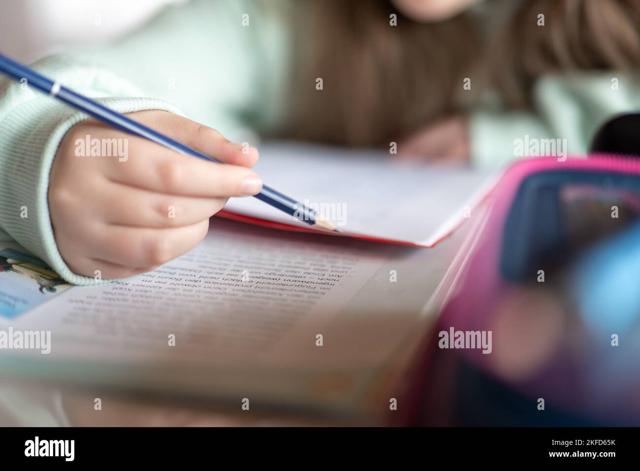 Girl writes words in a notebook.Study and education.schoolgirl does her ...