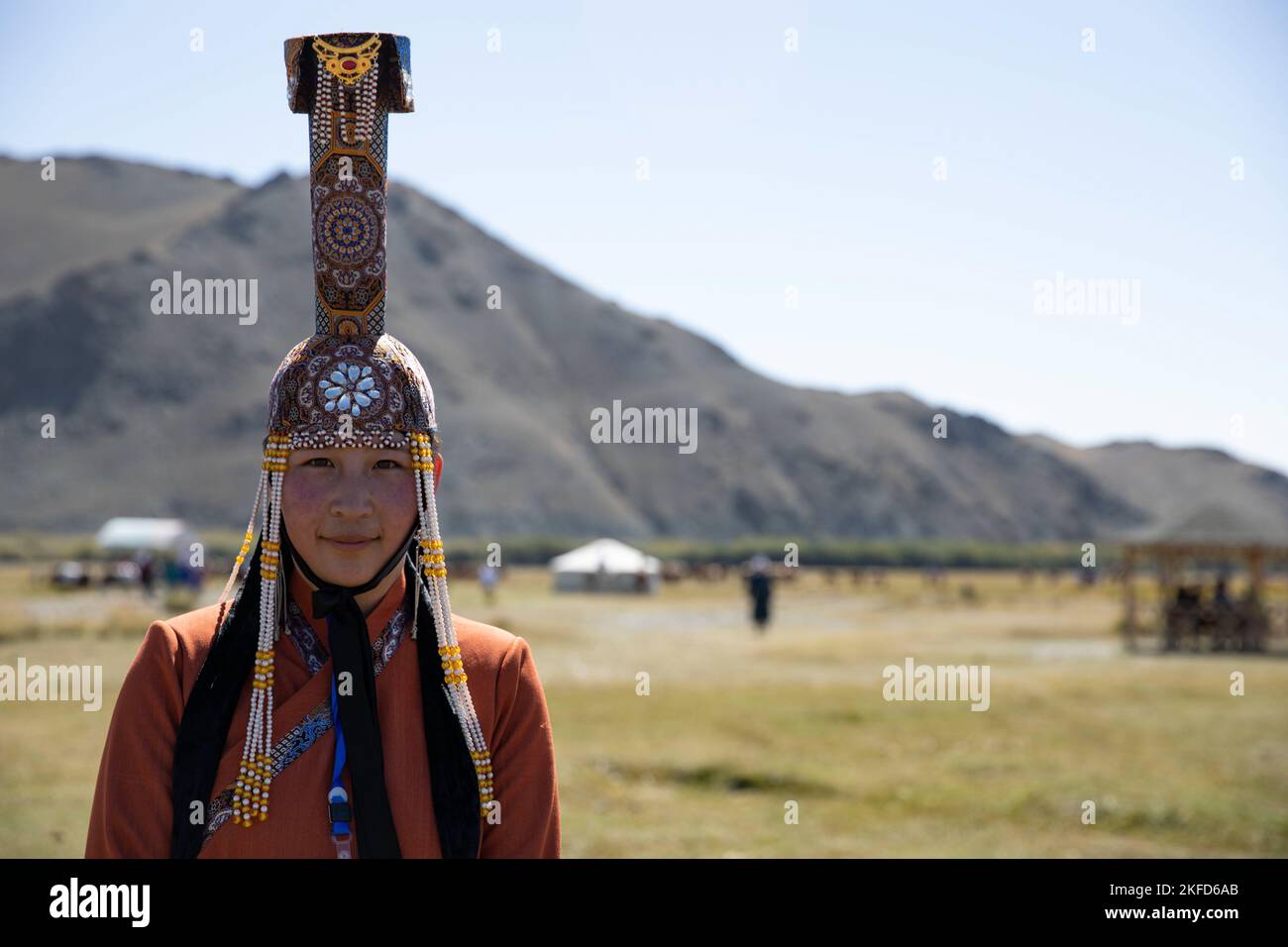 A Mongolian woman exhibits traditional dress and headwear during a ...