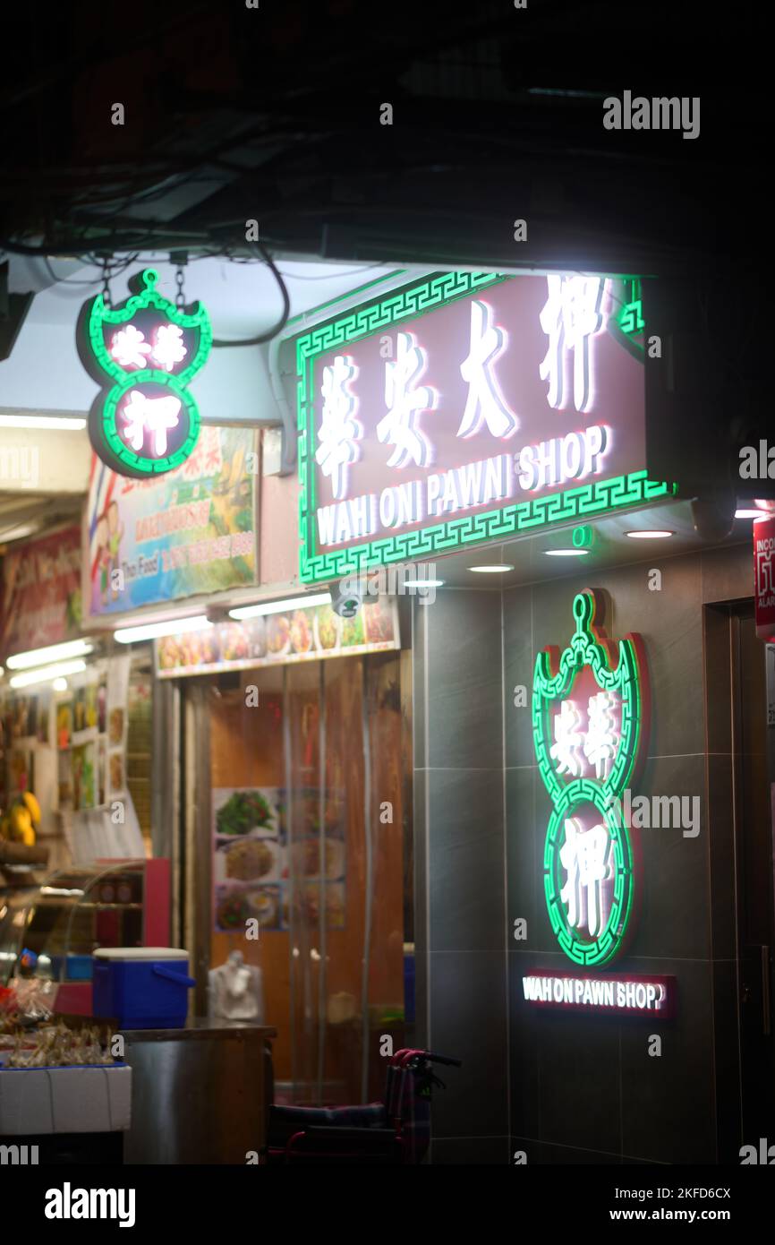 A vertical shot of the illuminated neon signs hanging on a building in ...