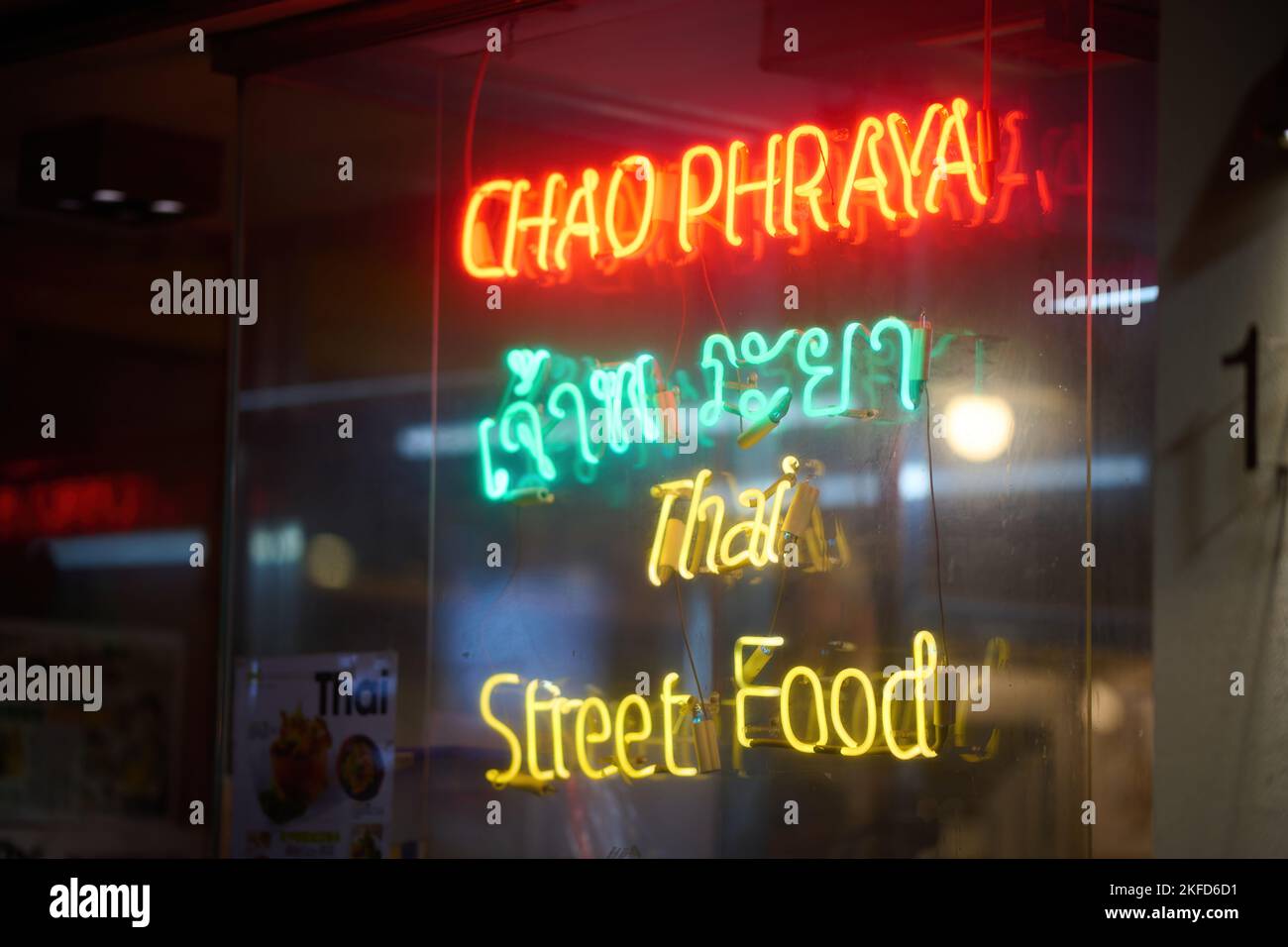 The illuminated neon sign of a Thai cuisine street food restaurant in ...