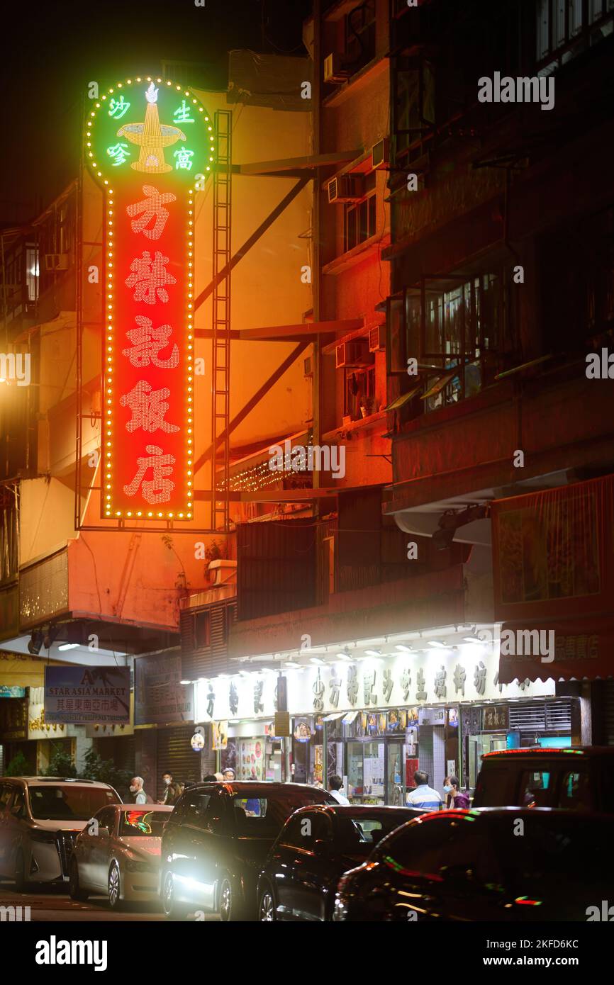 A vertical shot of an illuminated neon light sign on the street in ...