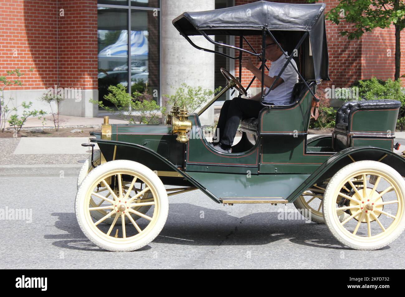 A man riding a classic old-style retro car in downtown Vancouver ...