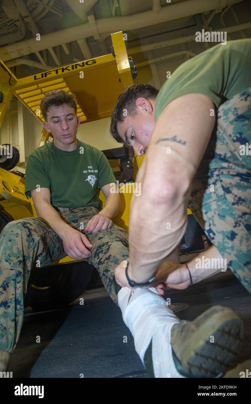 U.S. Marine Corps Sgt. Noah Johnson, applies a splint to Cpl. Julian Larsen, both scout snipers ...