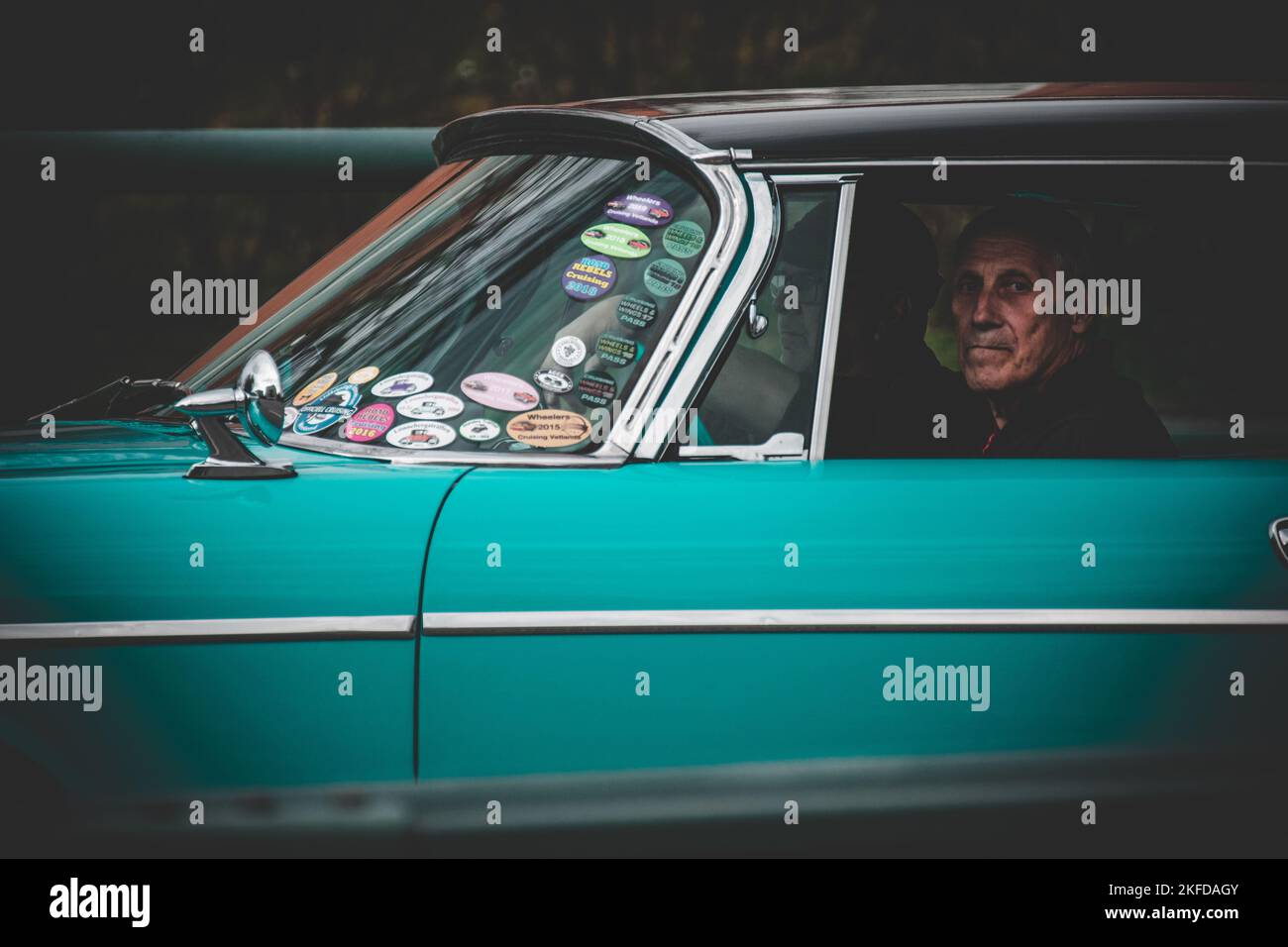 A man in a retro car at a cruising event with old and great cars in ...