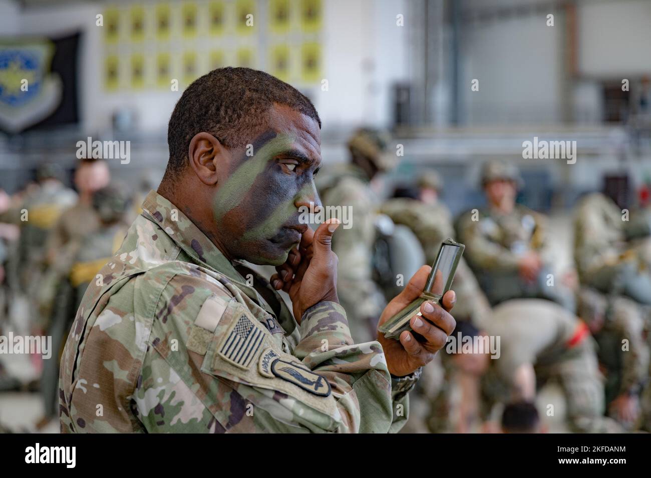 A U.S. Army soldier assigned to the 173rd Airborne Brigade applies face ...