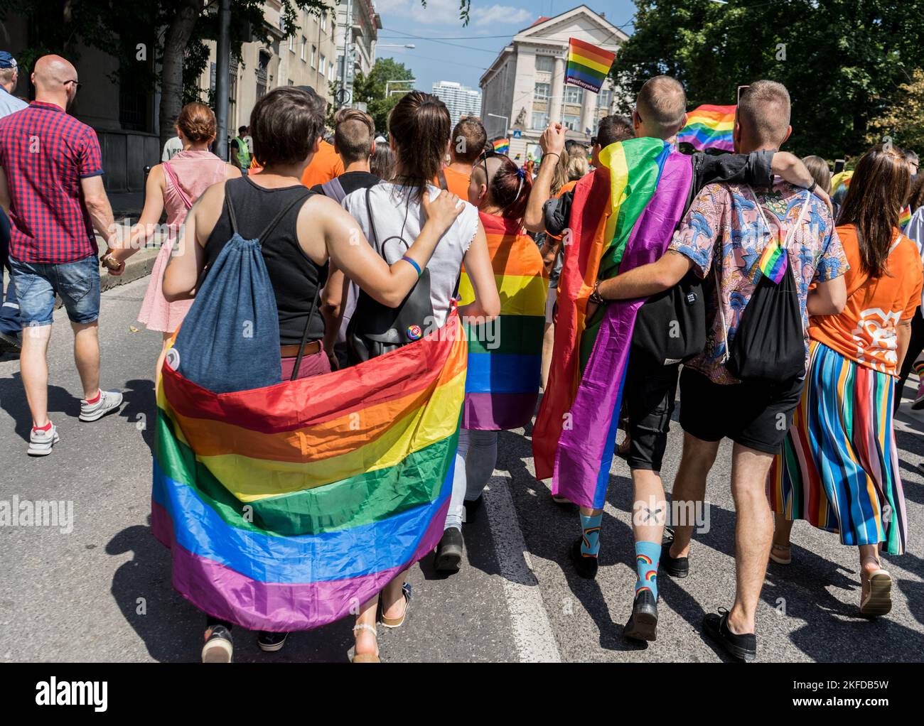 A group of people wearing rainbow flags marching for equal rights for ...