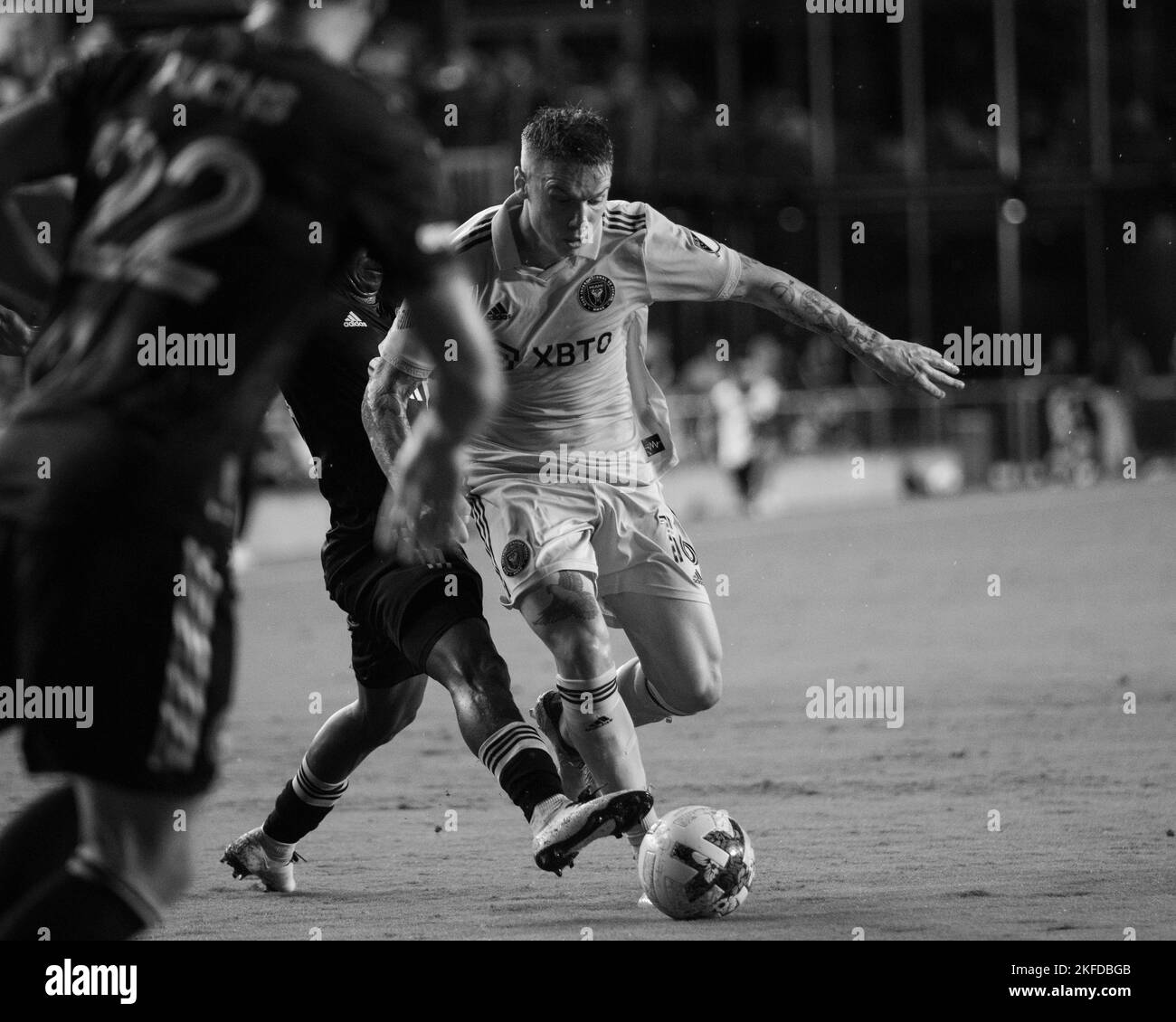 A grayscale shot of Robert Taylor Inter Miami CF running with the ball ...